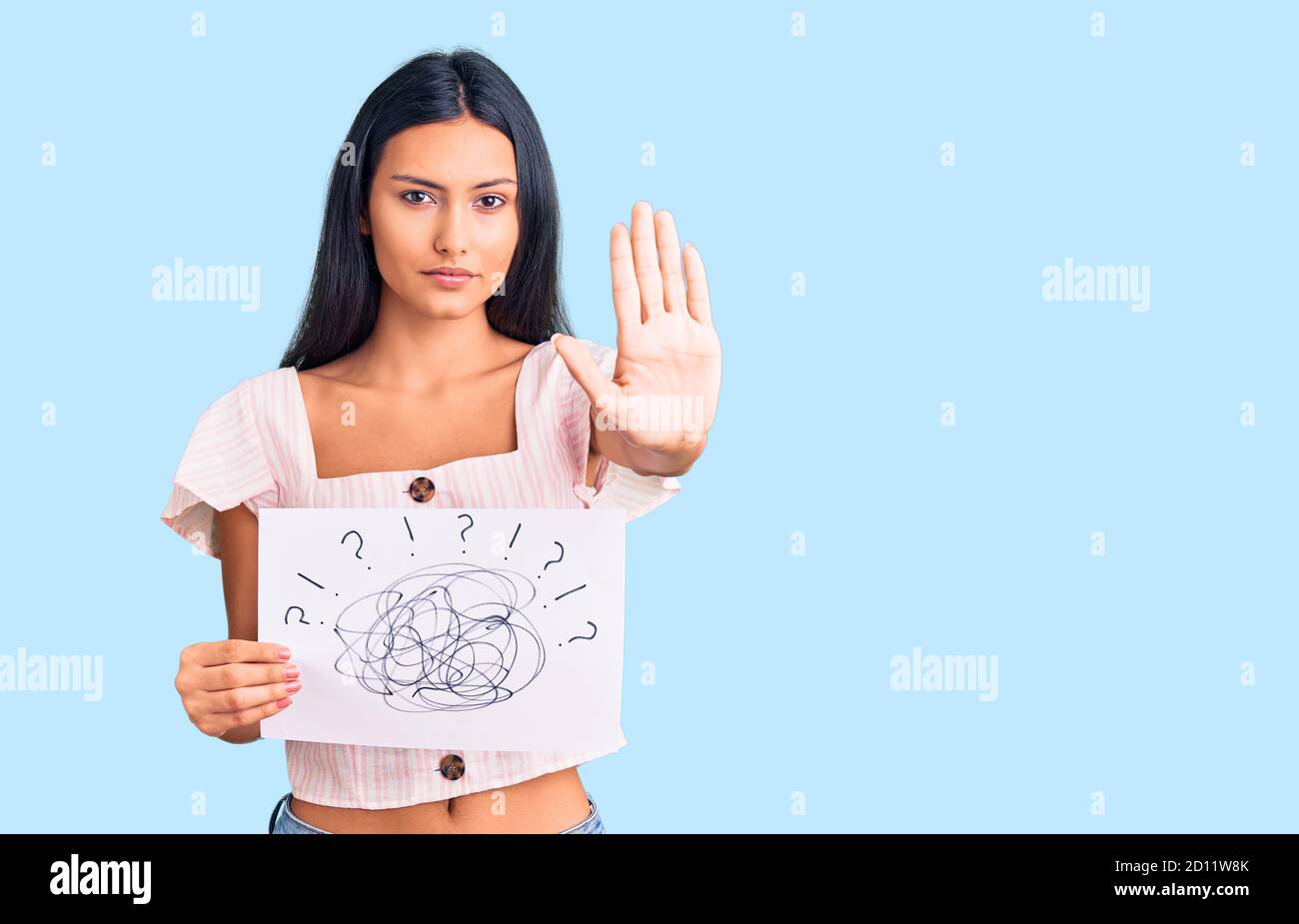 Young beautiful latin girl holding scribble draw with open hand doing ...