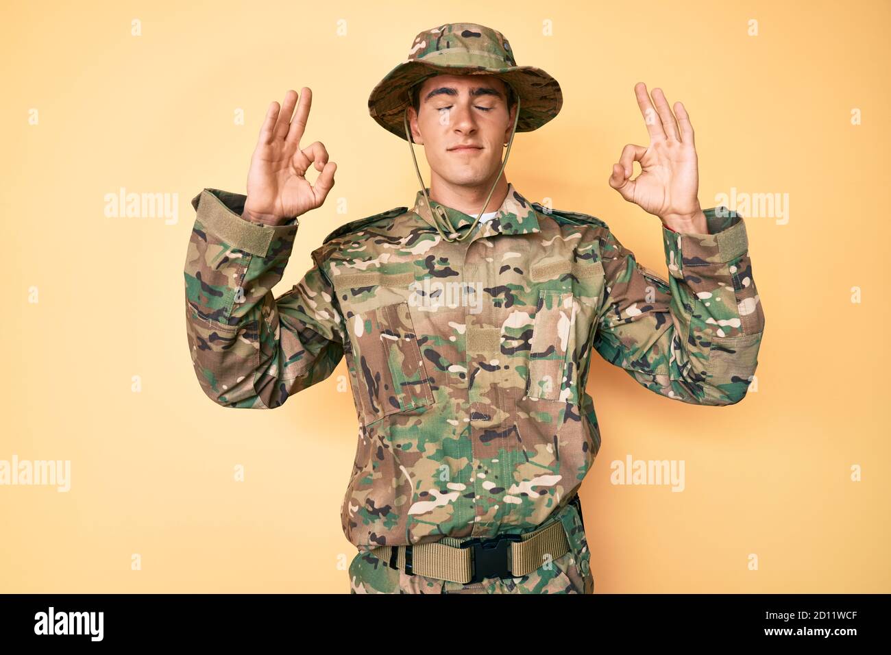 Young handsome man wearing camouflage army uniform relax and smiling ...