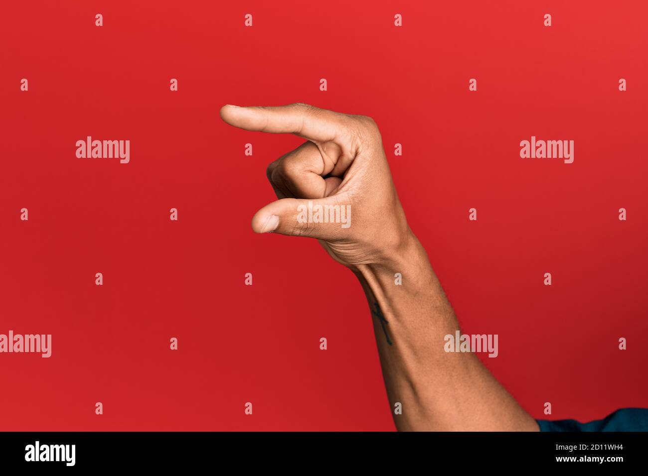 Hand of hispanic man over red isolated background picking and taking ...
