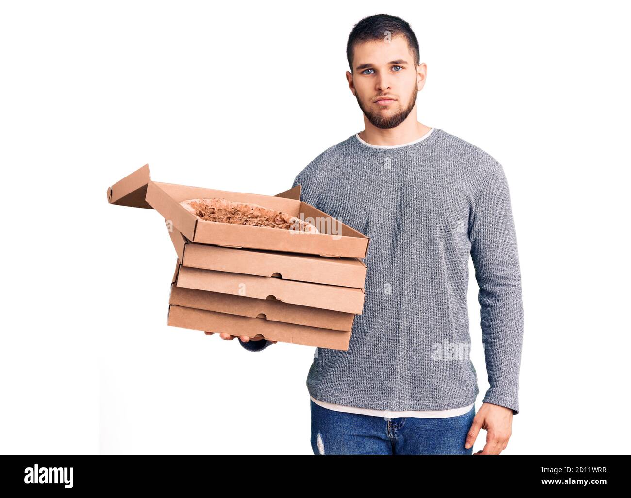 Young handsome man holding delivery italian pizza boxes thinking ...