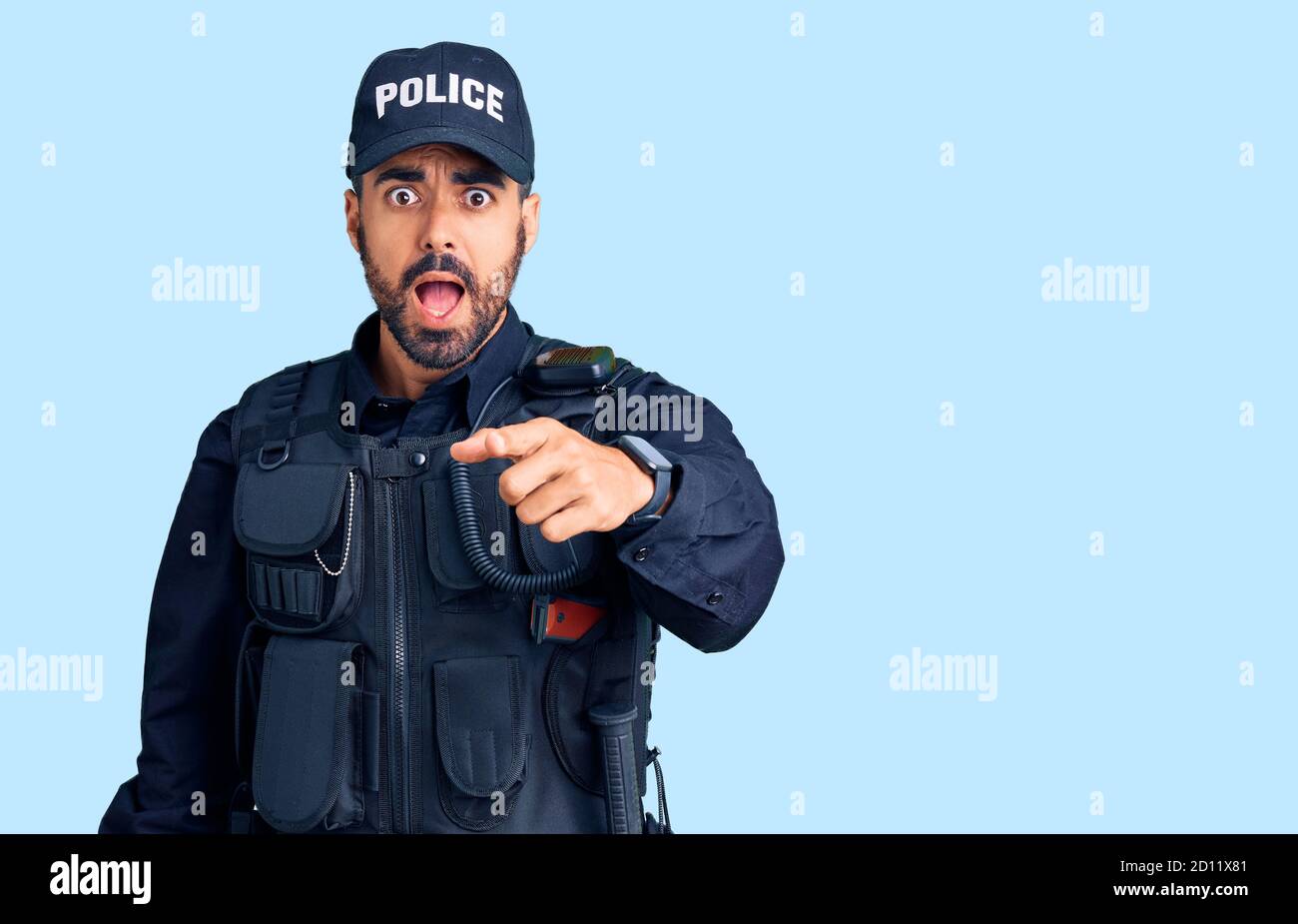 Young hispanic man wearing police uniform pointing displeased and ...