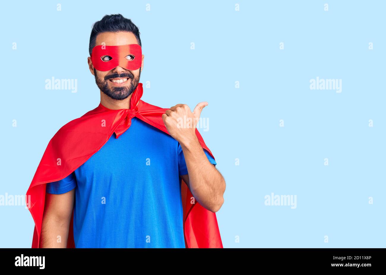 Young hispanic man wearing super hero costume smiling with happy face ...