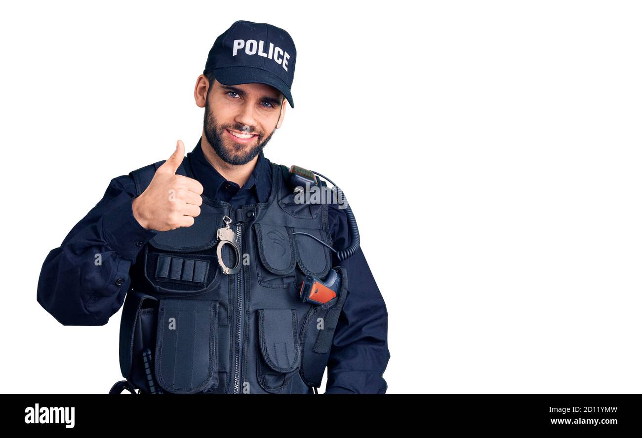Young handsome man with beard wearing police uniform doing happy thumbs ...