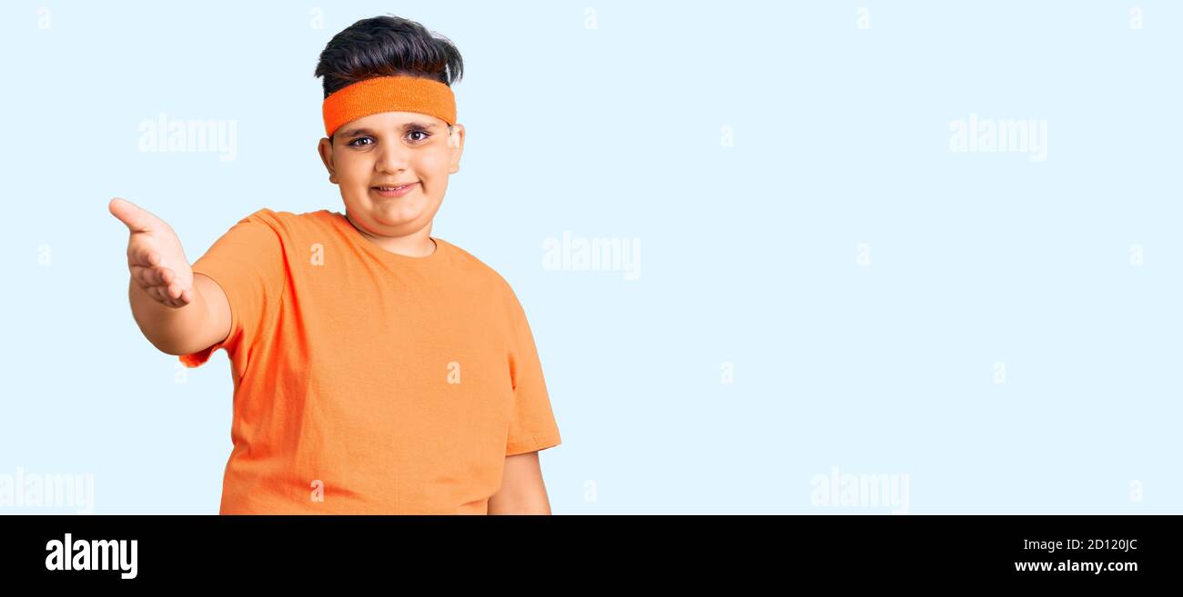 Little boy kid wearing sportswear smiling friendly offering handshake ...