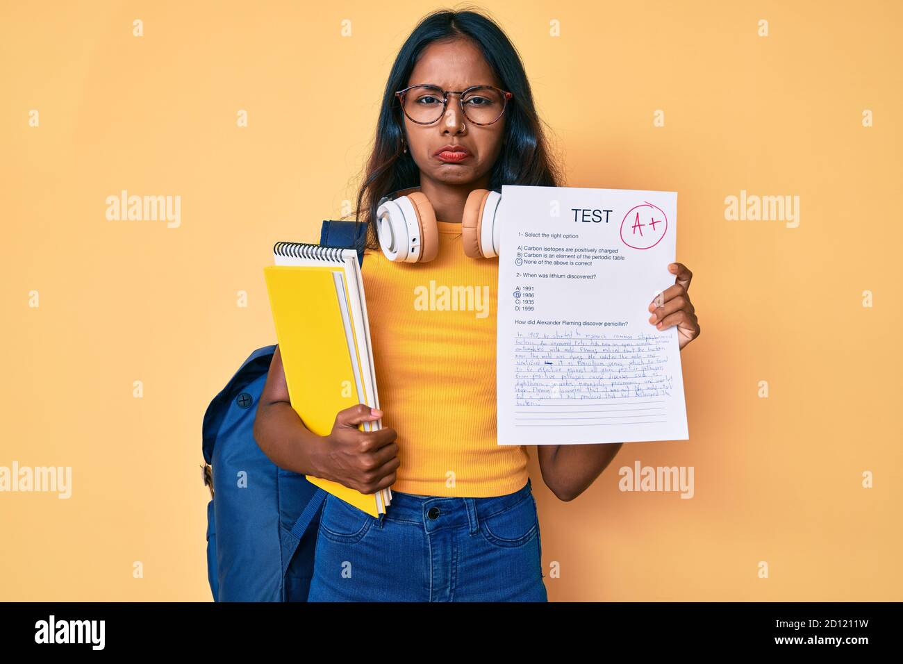 Young indian girl wearing backpack showing a passed exam depressed and ...