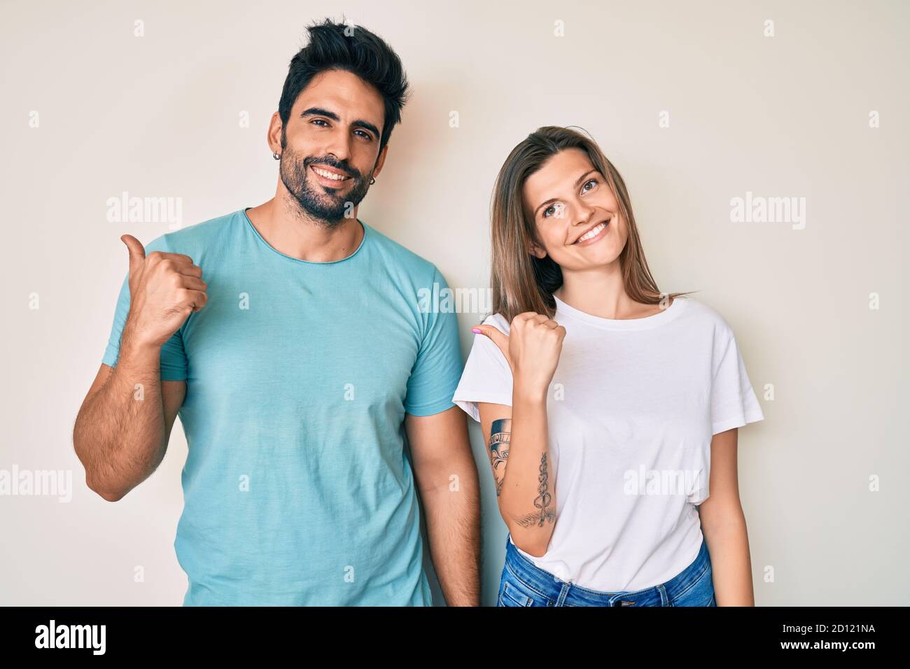 Beautiful young couple of boyfriend and girlfriend together pointing to ...