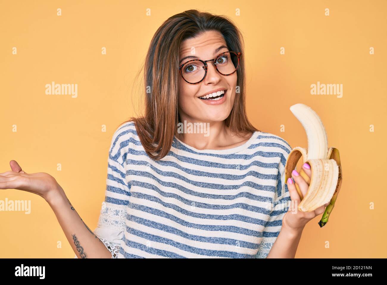 Beautiful caucasian woman eating banana as healthy snack celebrating ...