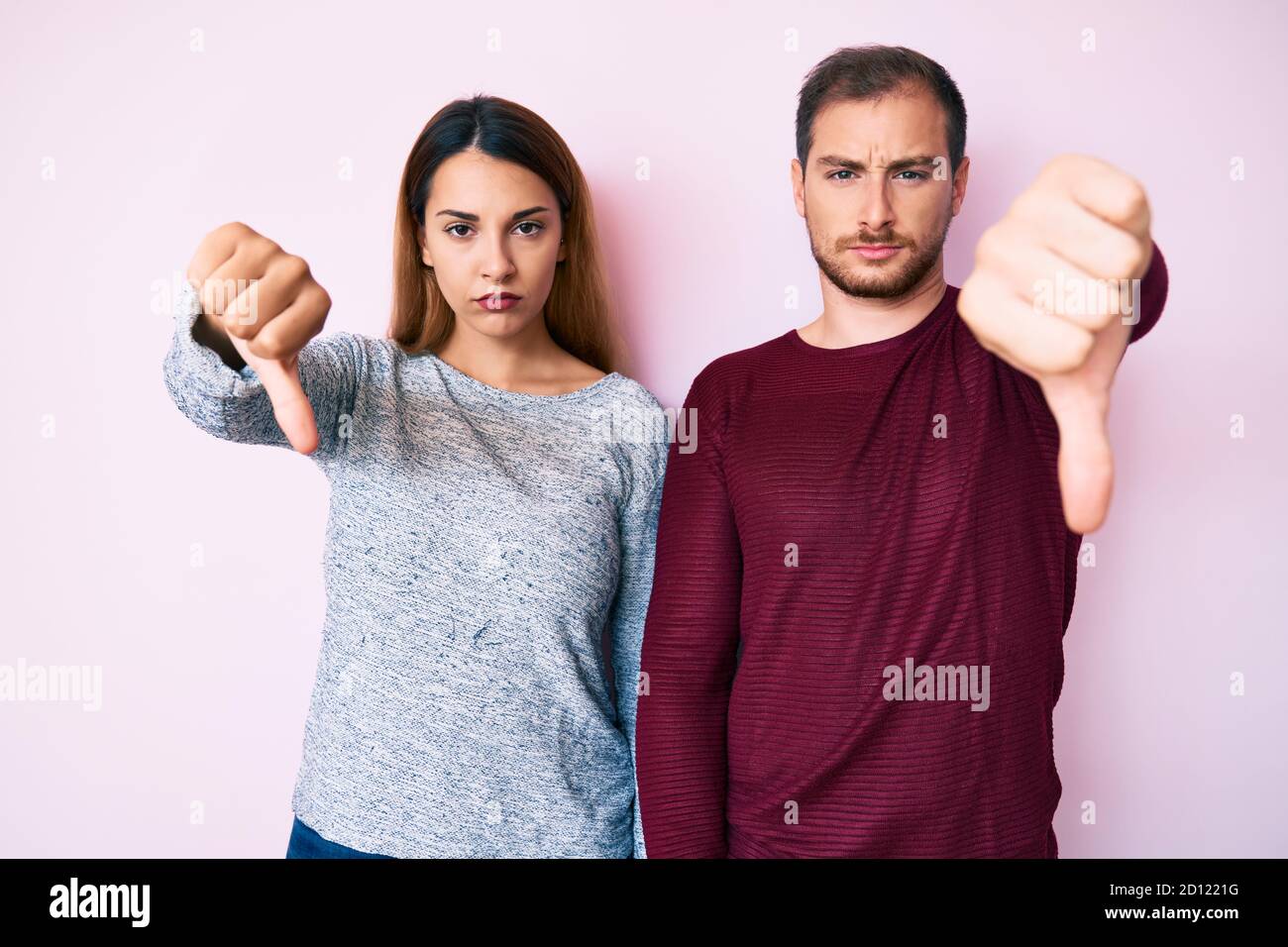 Beautiful couple wearing casual clothes looking unhappy and angry ...