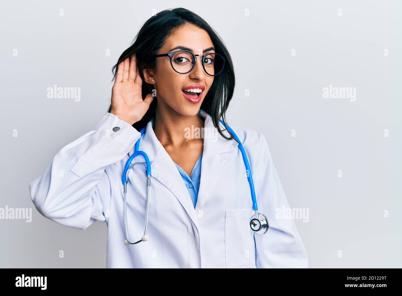Beautiful hispanic woman wearing doctor uniform and stethoscope smiling ...