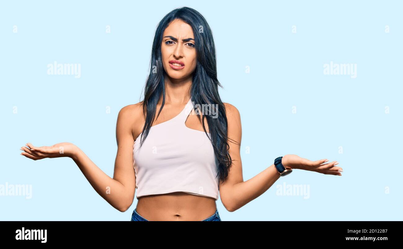 Beautiful hispanic woman wearing casual clothes clueless and confused ...
