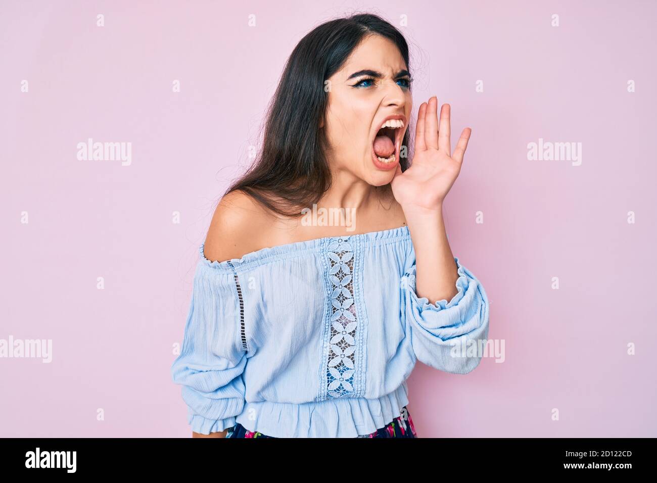 Brunette teenager girl wearing casual clothes shouting and screaming ...