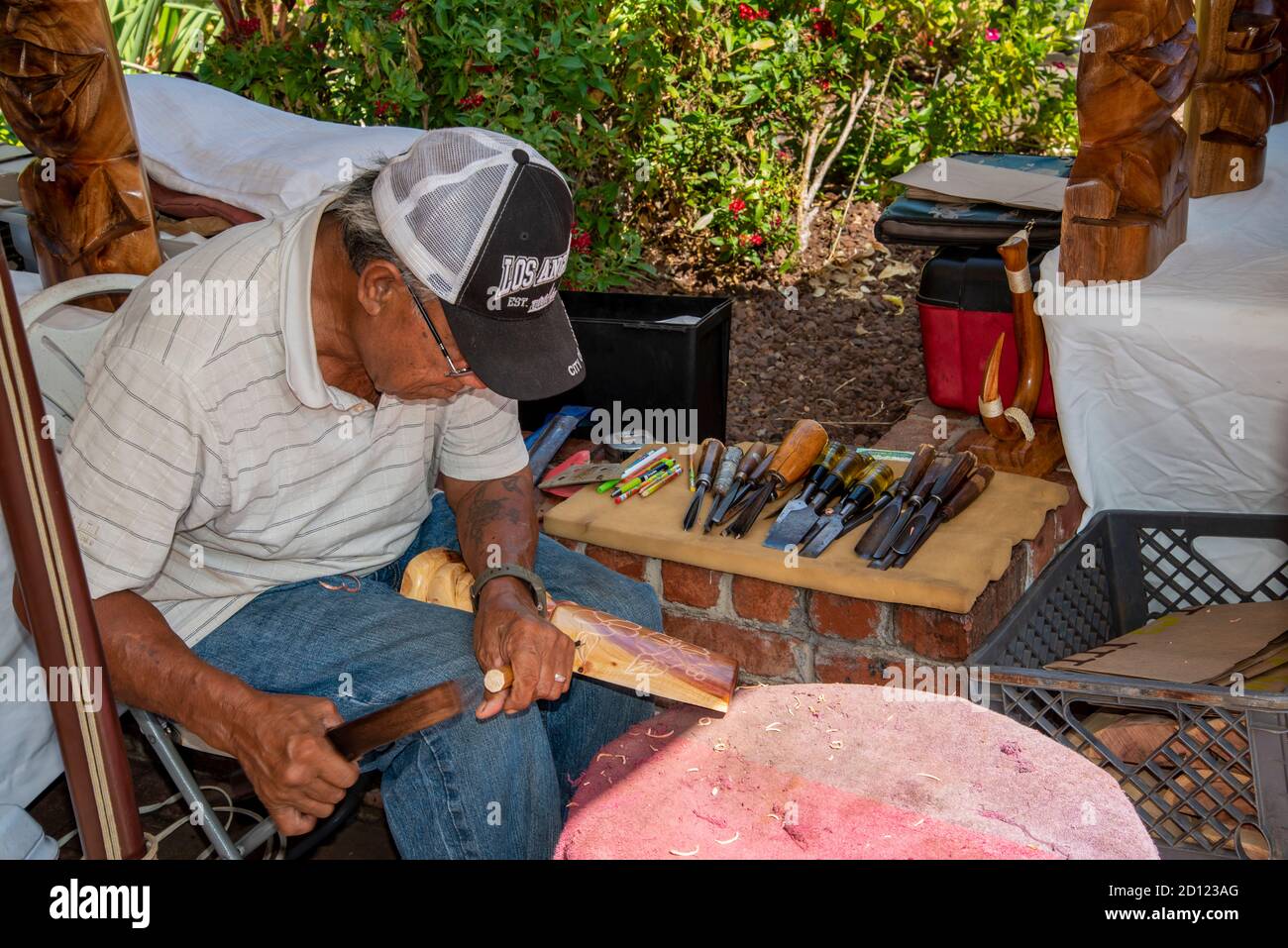 Maui, Hawaii. Wood carver using his tools to make carvings for ...