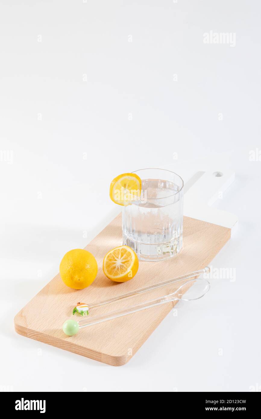 Lemon & ice cube water on wooden serving board white background Stock Photo - Alamy