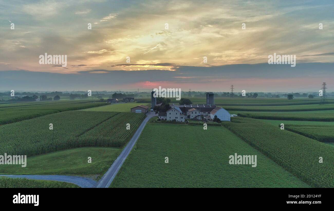 Aerial view of a summer sunset over farm lands with blue skies and red ...