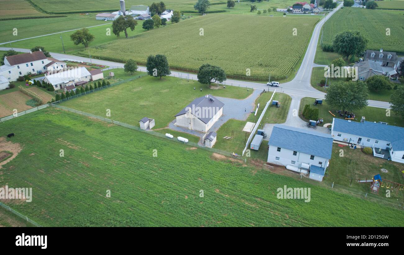 Aerial view of Amish countryside with barns and silos and a one room ...
