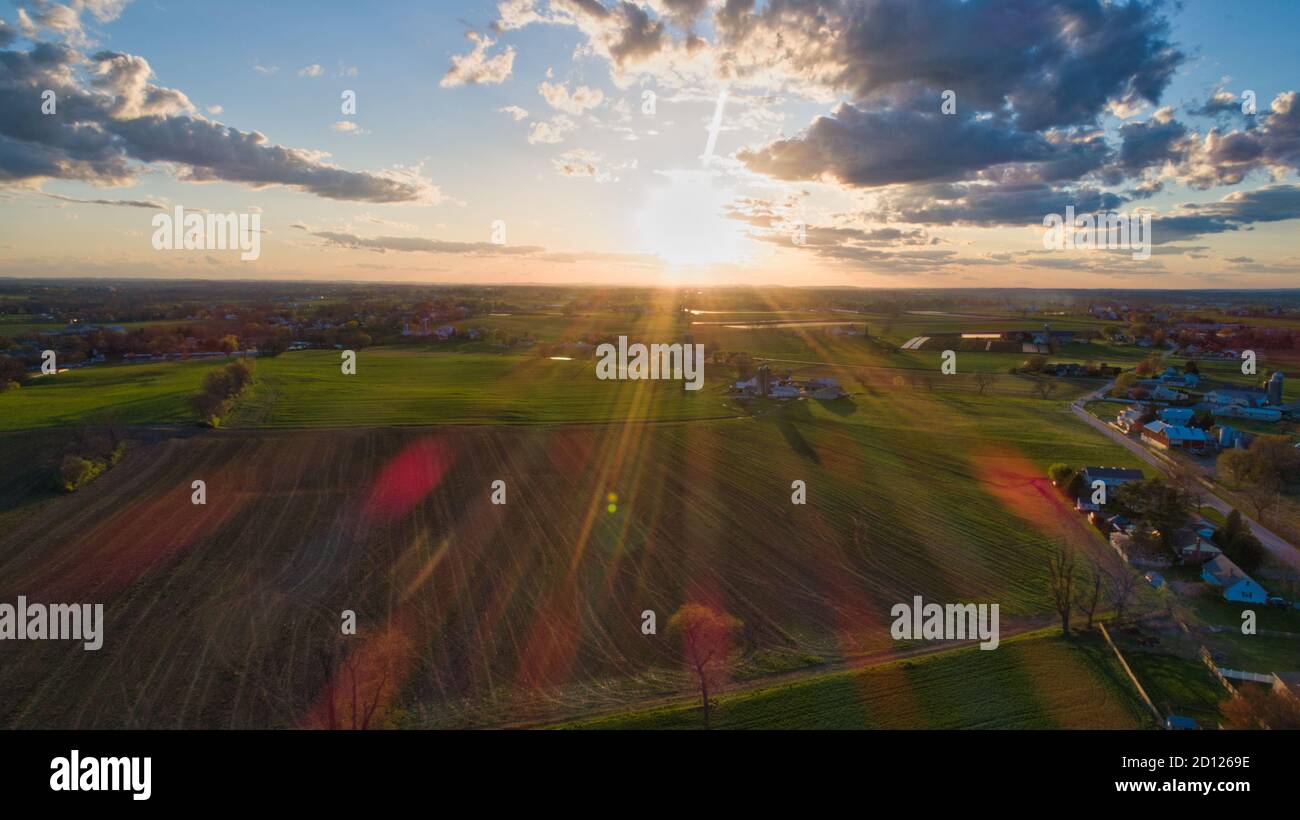 Aerial view of a Sunset over barns, silos and farmlands during the ...