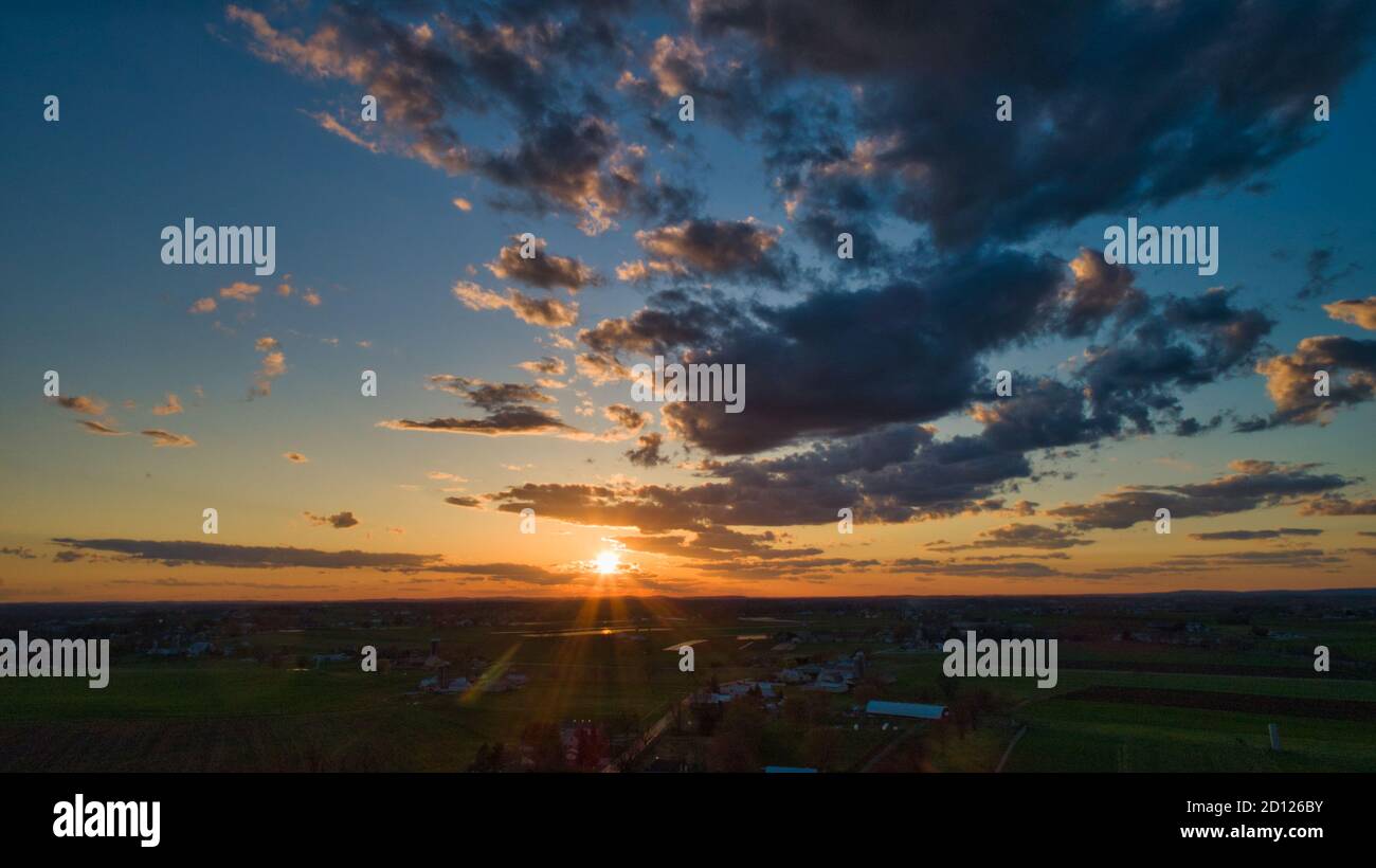 Aerial view of a Sunset over barns, silos and farmlands during the ...