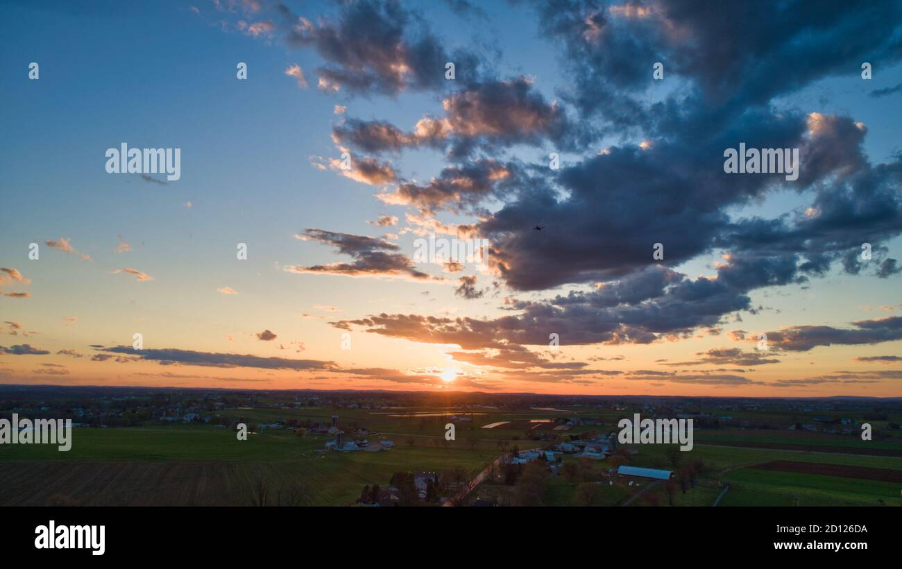 Aerial view of a Sunset over barns, silos and farmlands during the ...