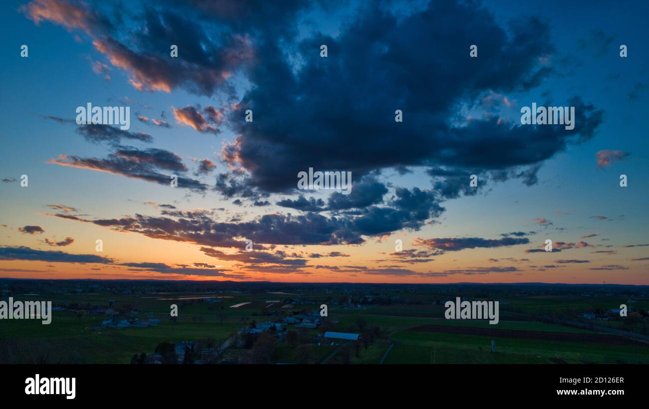 Aerial view of a Sunset over barns, silos and farmlands during the ...