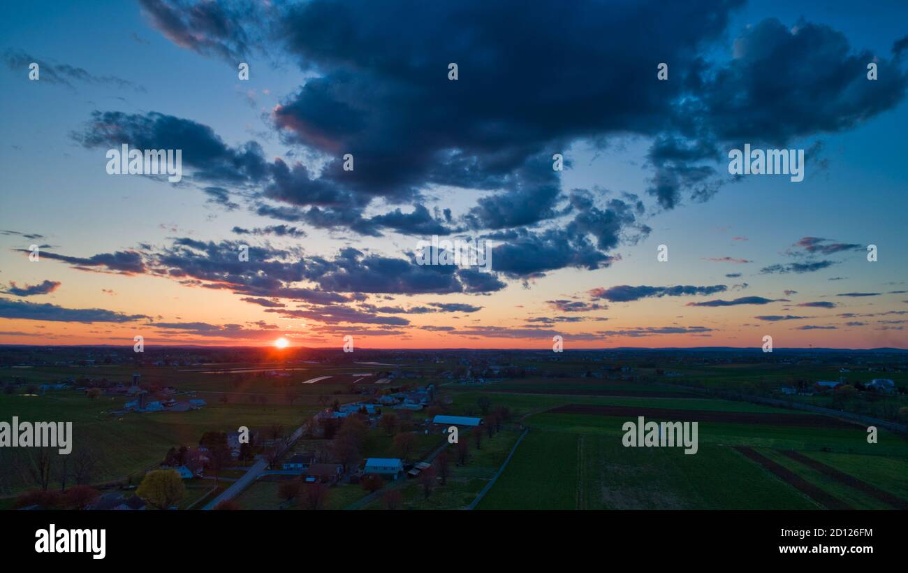 Aerial view of a Sunset over barns, silos and farmlands during the ...