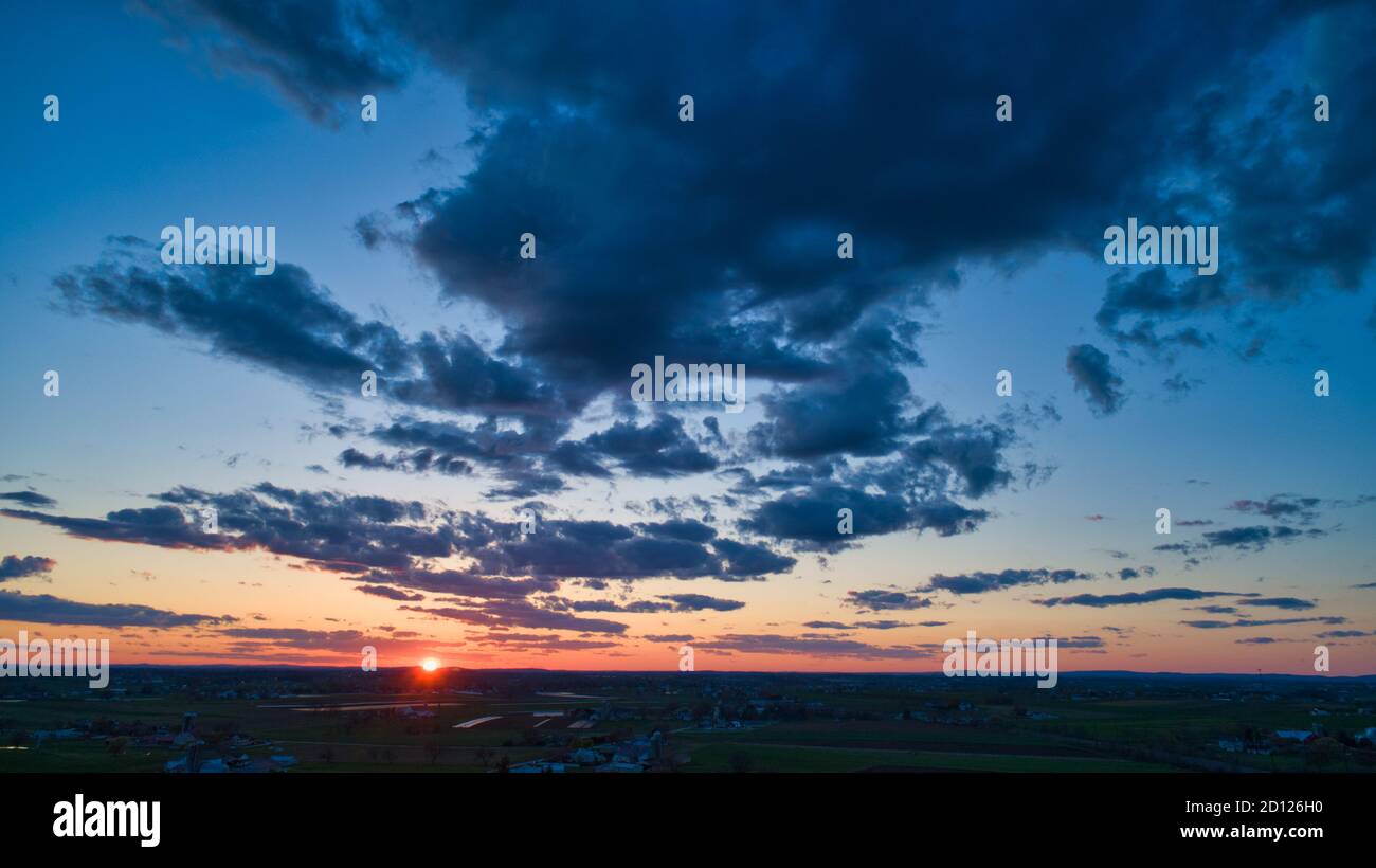 Aerial view of a Sunset over barns, silos and farmlands during the ...