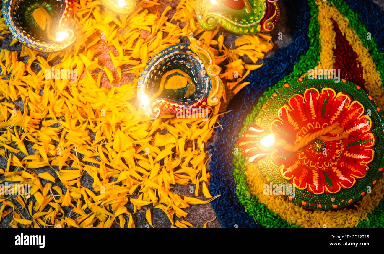 Close up clay lit light a fire already on Diya or oil lamp with flowers ...