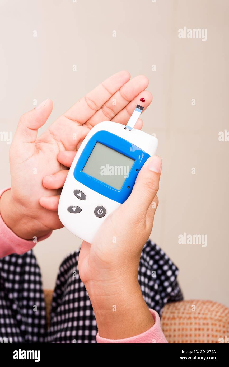 Closeup Hands woman measuring glucose test level check with blood on ...