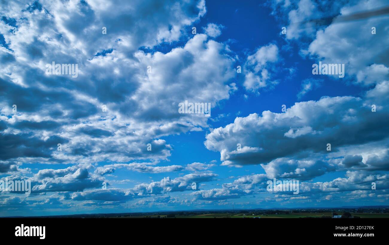 Blue sky and multiple clouds background Stock Photo - Alamy