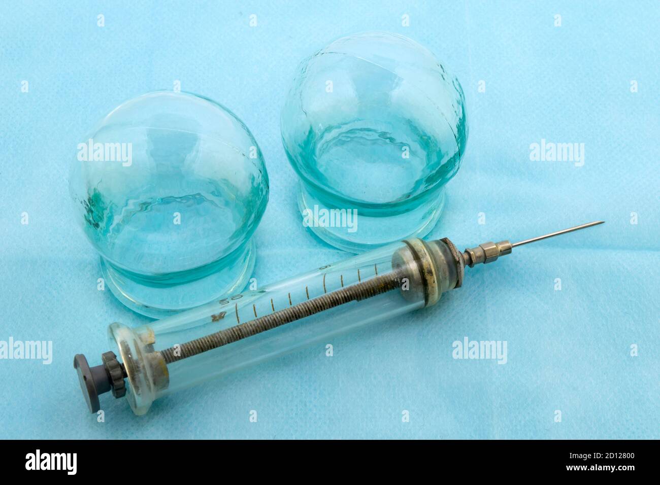 glass massage medical jars and an old glass syringe on a blue medical ...