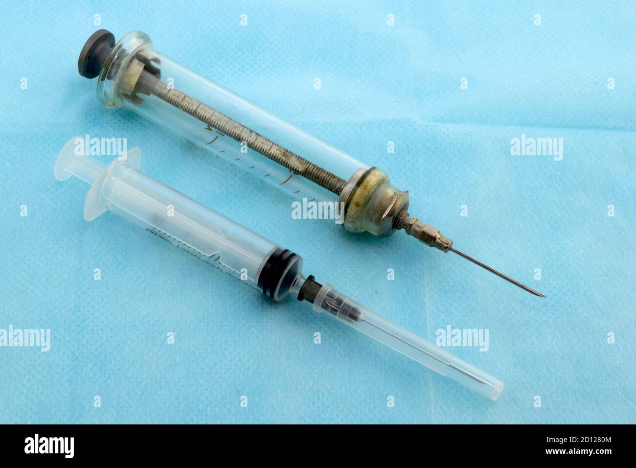 old glass and plastic disposable syringes on a blue medical sheet Stock ...