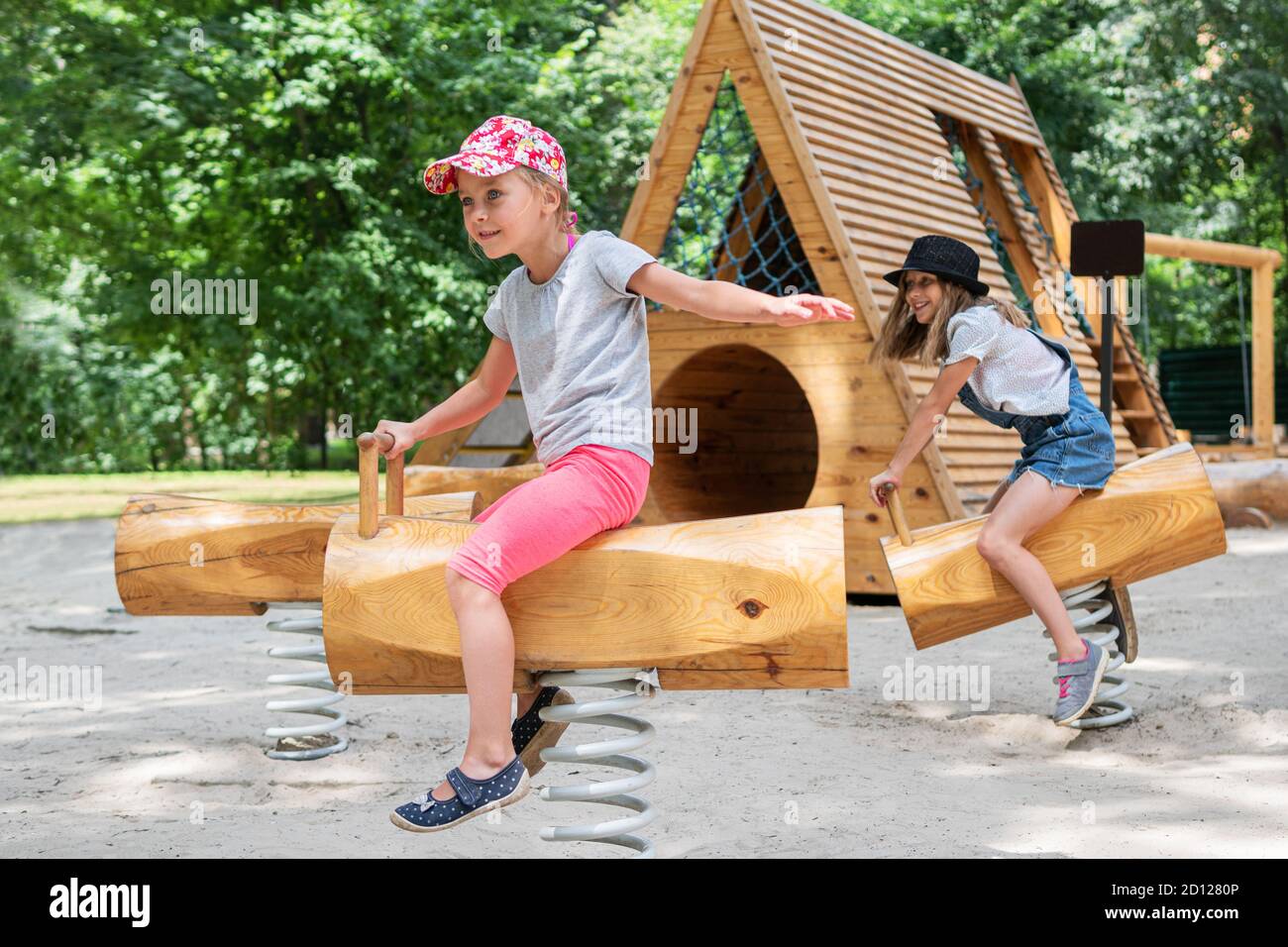 Children riders on wooden swing with spring on the playground in the ...