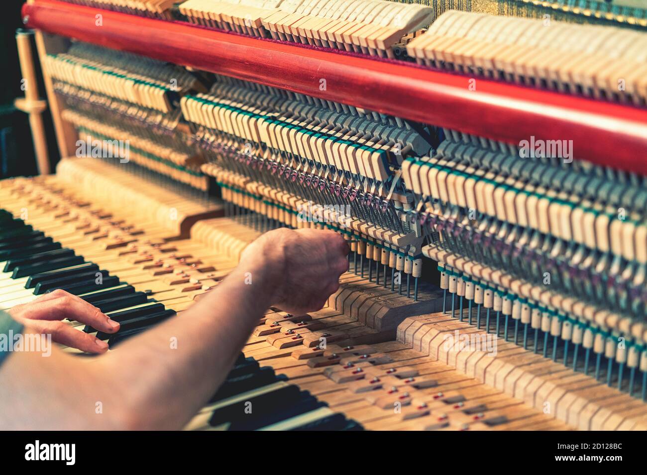 Piano tuning process. closeup of hand and tools of tuner working on ...