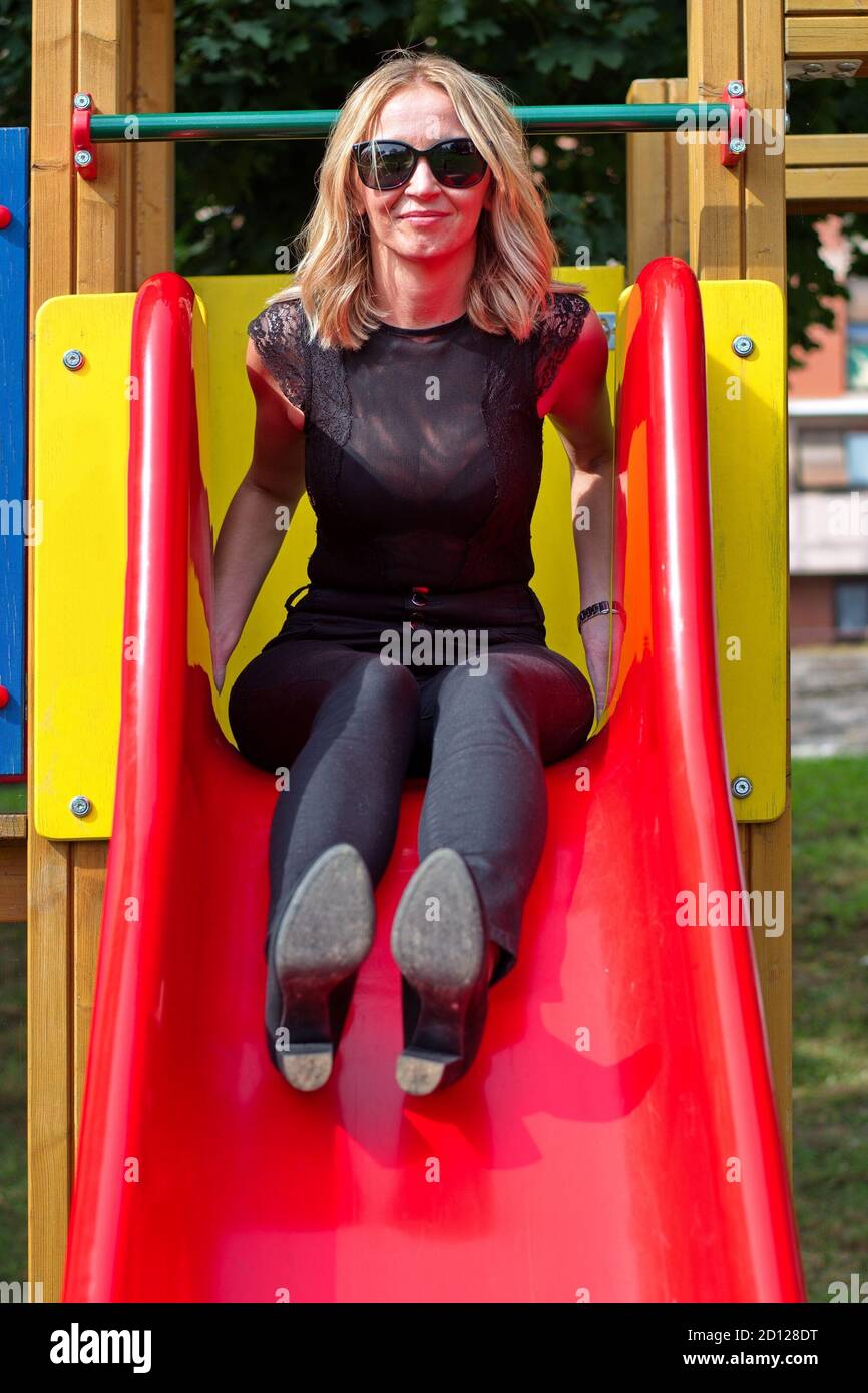 Portrait of mature woman having fun on a playground Stock Photo - Alamy