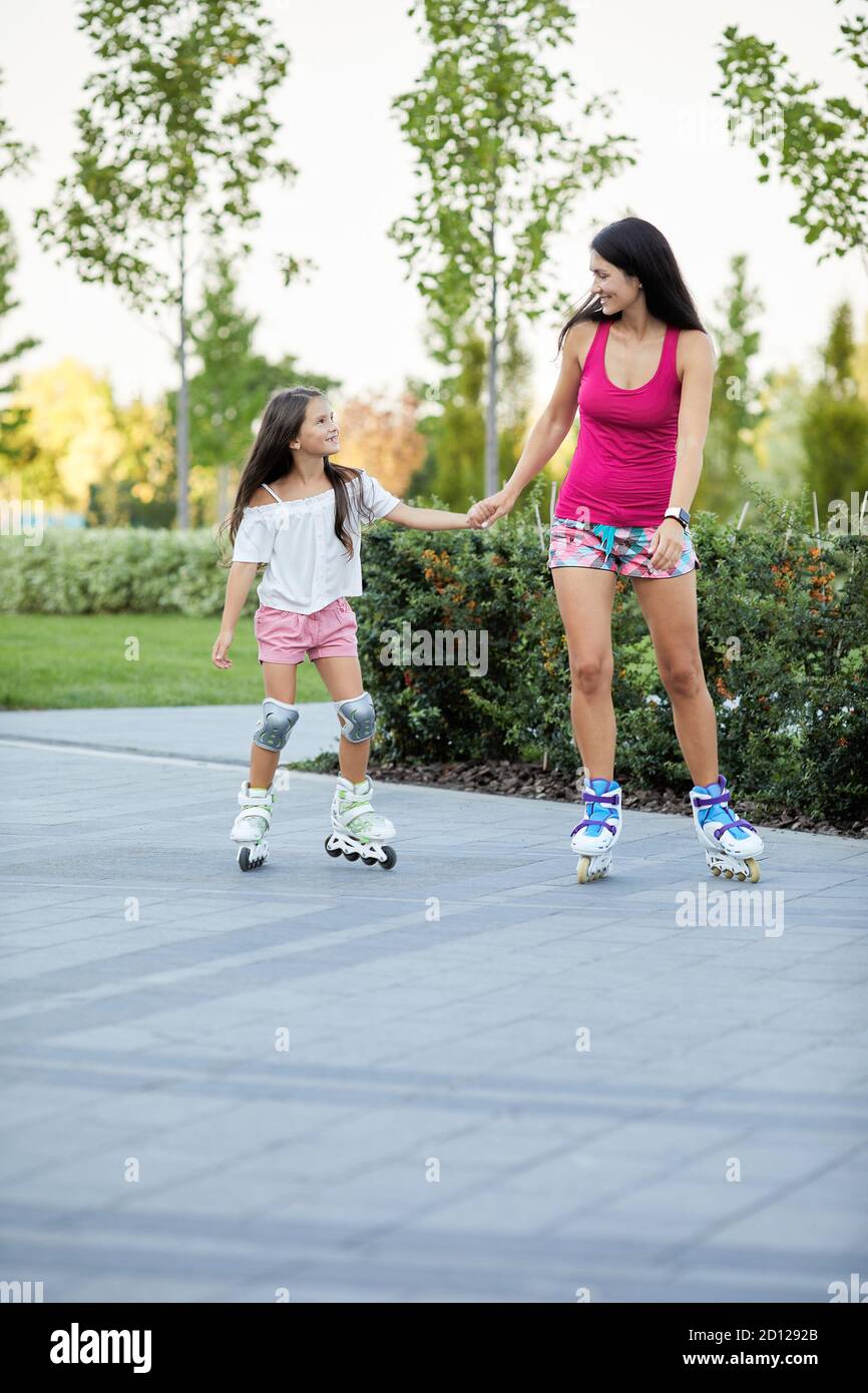 Young mother and her little daughter rollerskating in park. family having fun outdoor Stock ...