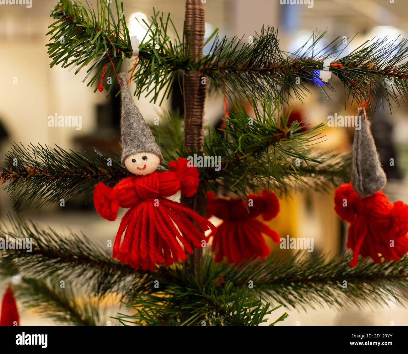 Handmade doll of red threads hanging on a branch of a Christmas tree ...
