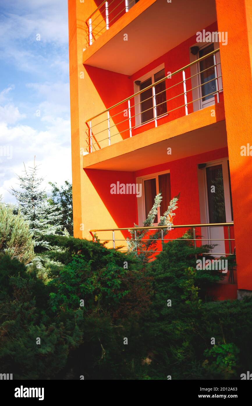 bright orange modern building with greenery in front of windows Stock ...