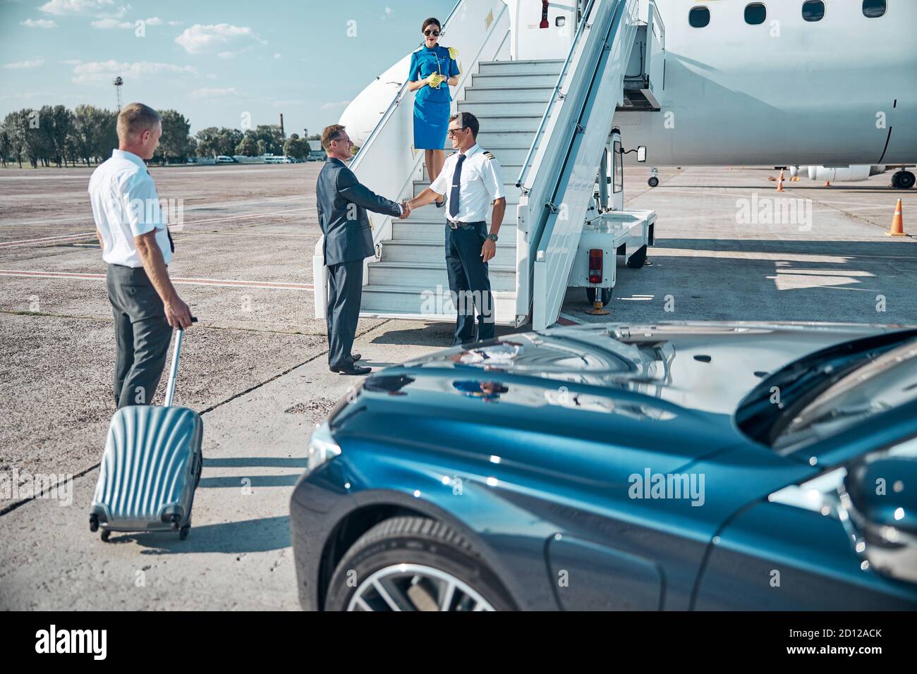 Jet staff meeting vip passenger on stairway Stock Photo - Alamy