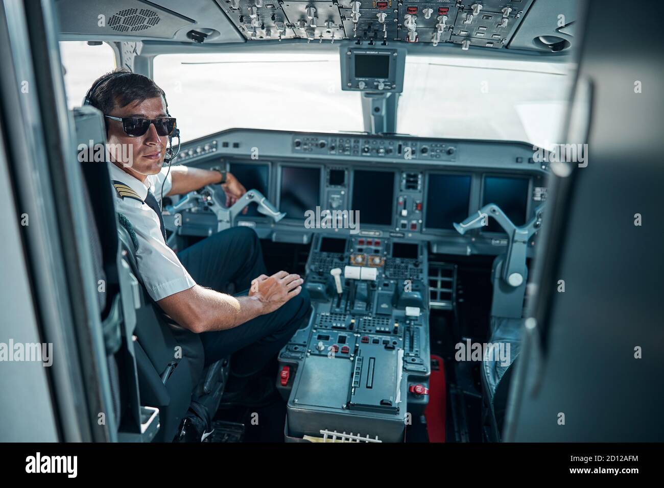 Smiling handsome pilot sitting in plane cockpit Stock Photo - Alamy