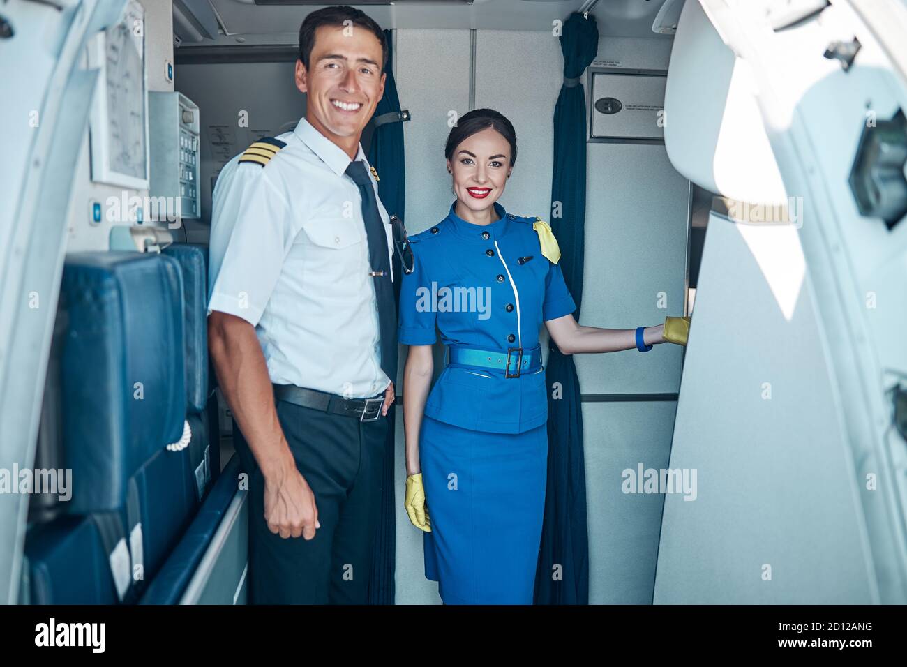 Smiling crew meeting passengers on plane board Stock Photo - Alamy
