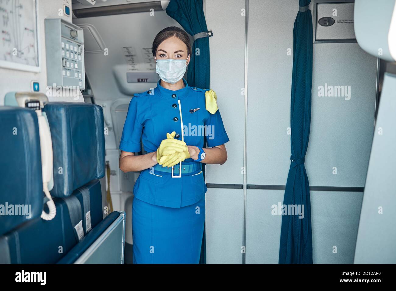Beautiful stewardess working on board during pandemic Stock Photo - Alamy