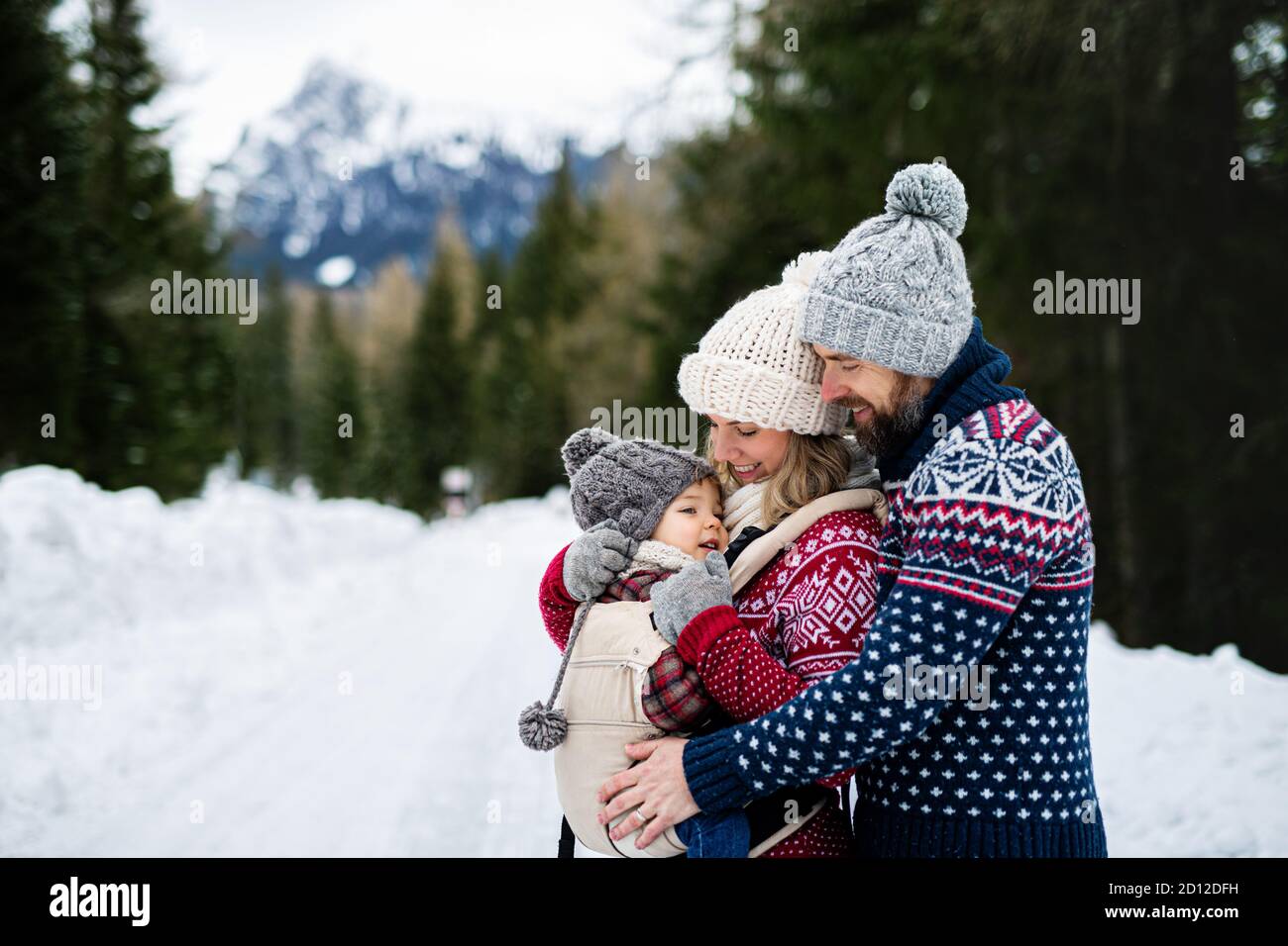 Father and mother with small child in winter nature, standing in the ...