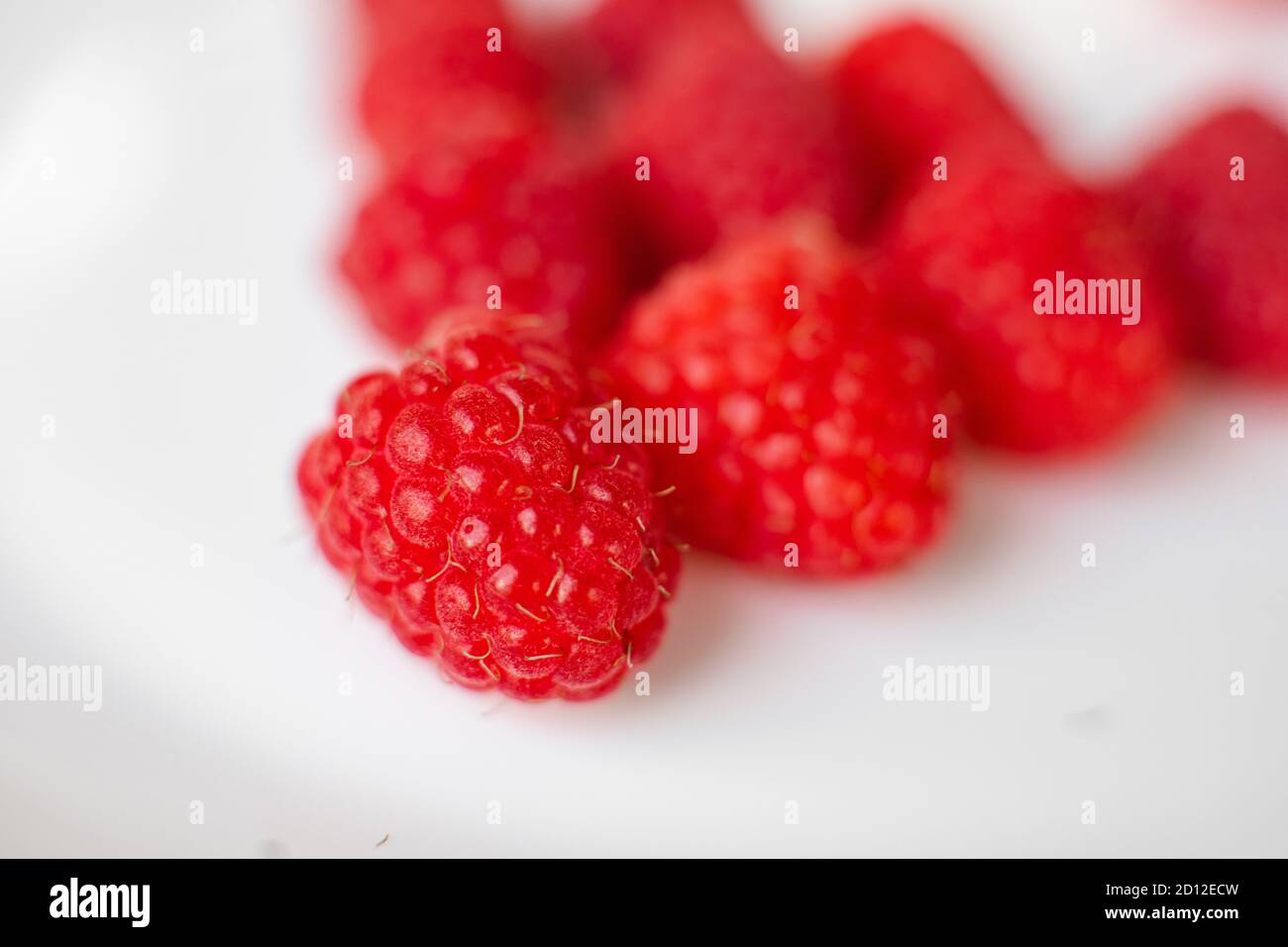 A picture of a few raspberries lies on a white background. Background ...