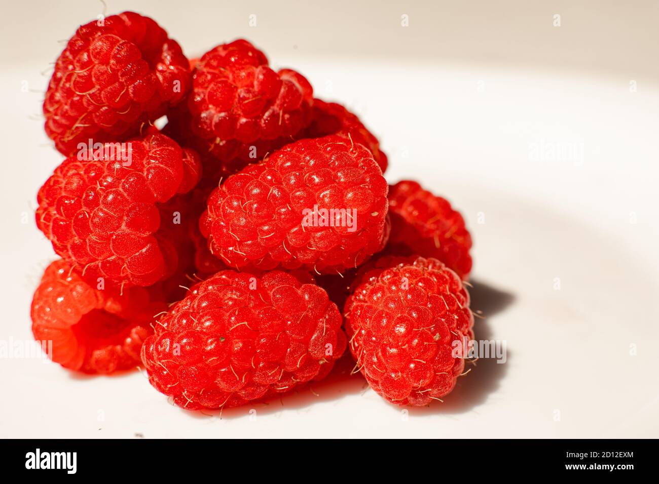 A picture of a few raspberries lies on a white background. Background ...