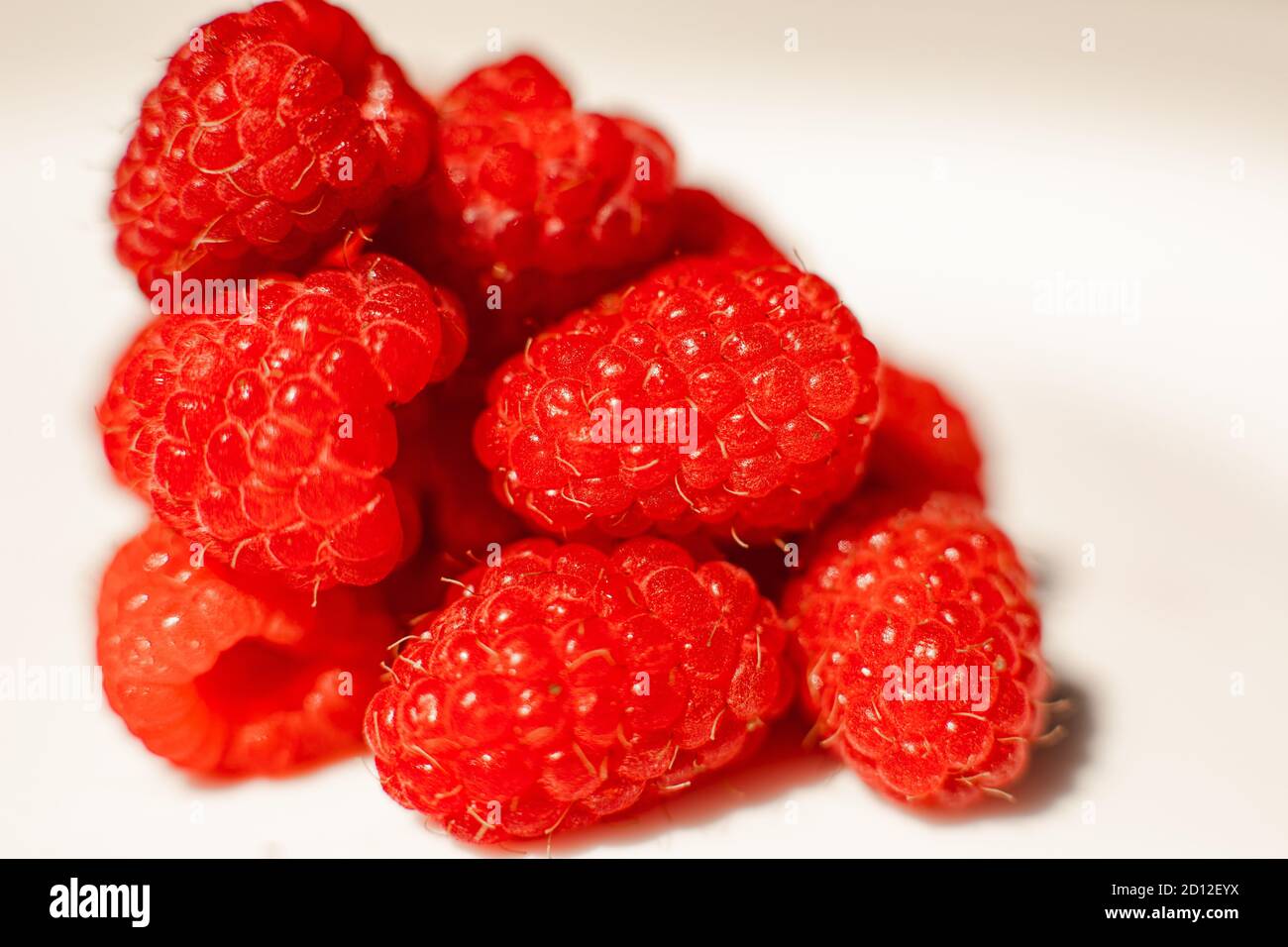 Beautiful raspberries in triangle shape lies isolated on a white ...