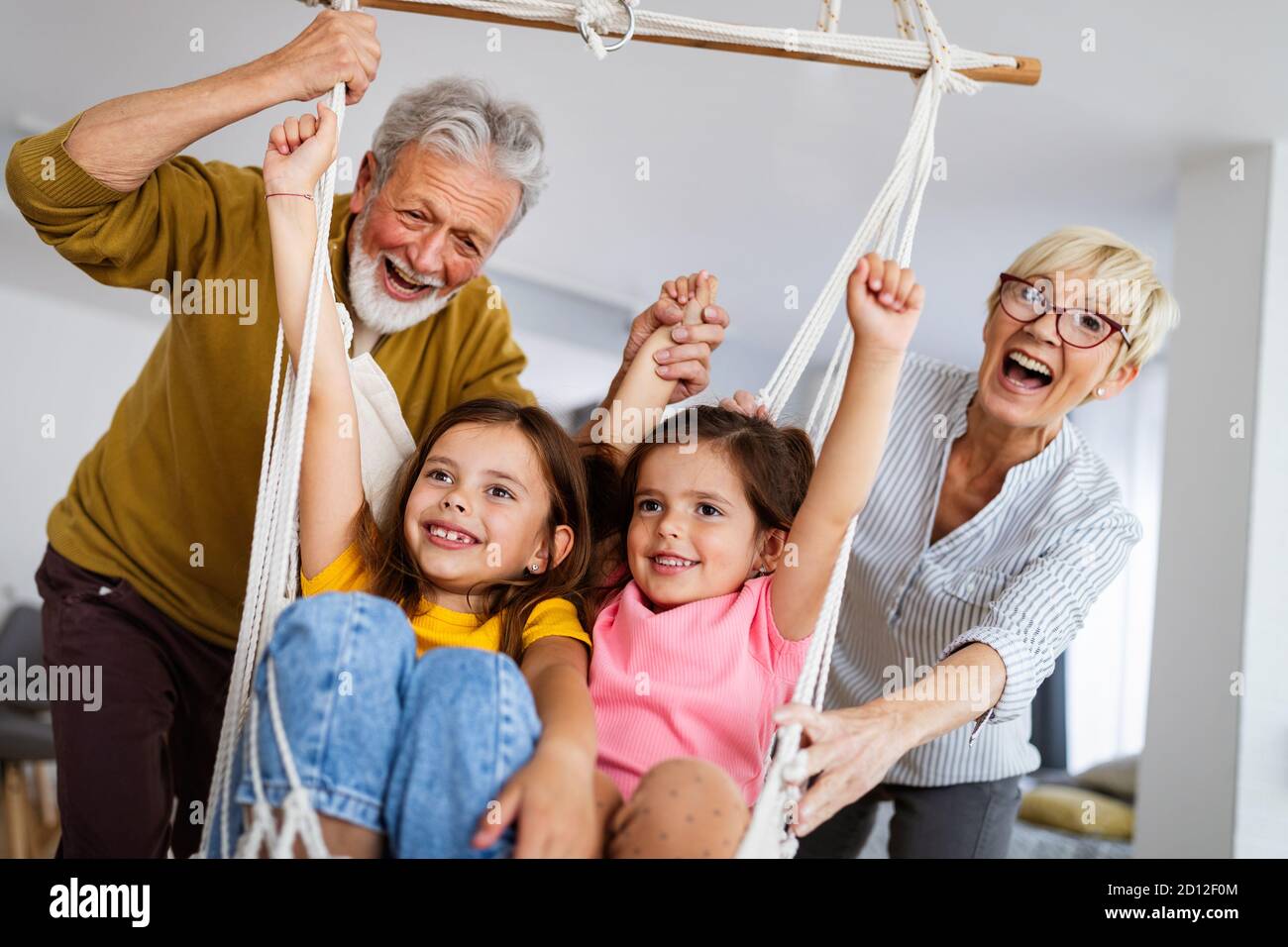 Grandchildren having fun, playing with grandparents at home Stock Photo ...
