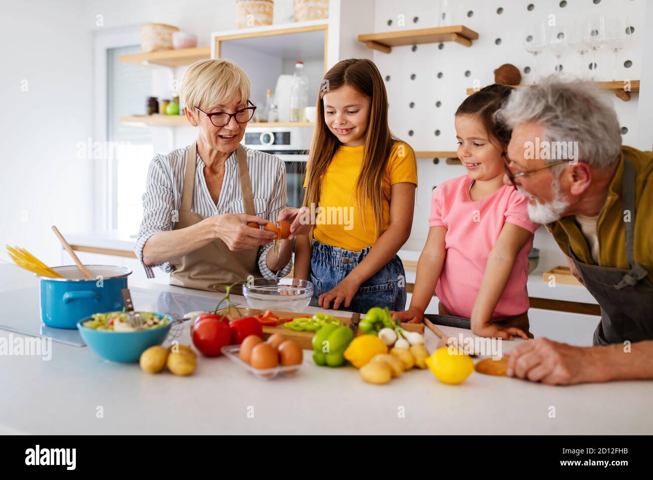 Cheerful family spending good time together while cooking in kitchen ...
