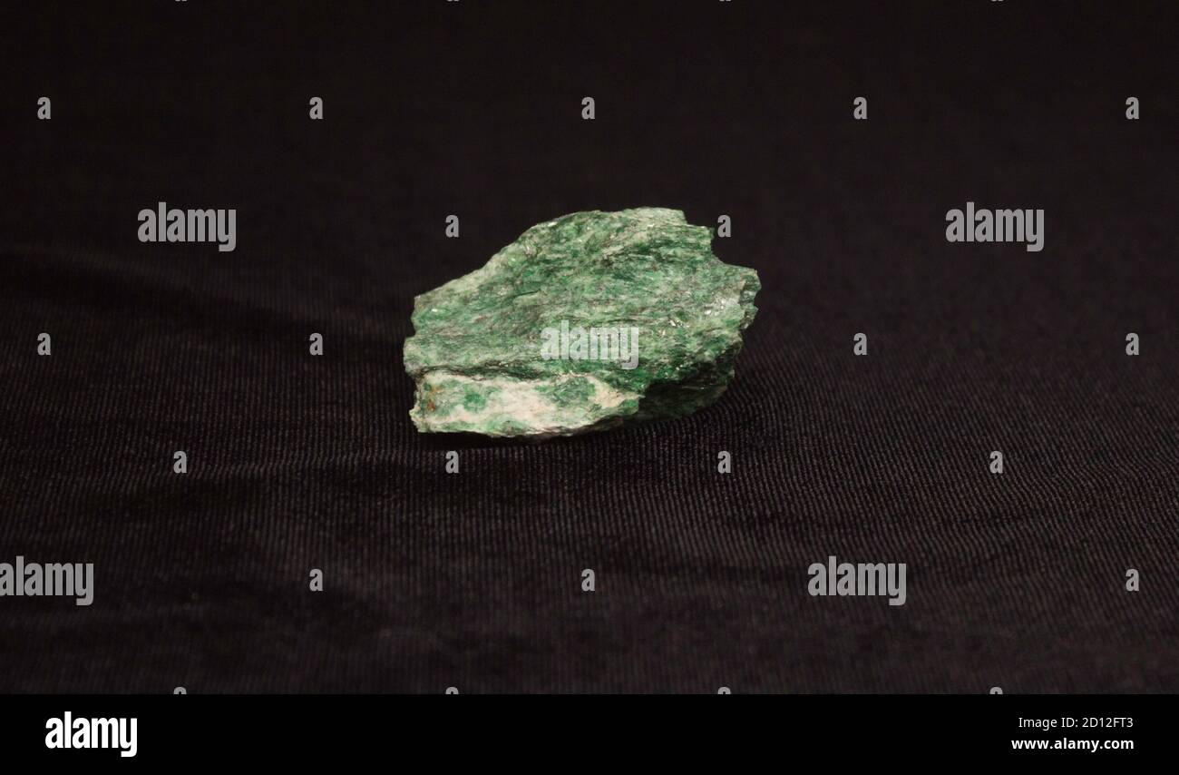 Fuchsia mineral, mica. The stone is green on a black background Stock ...