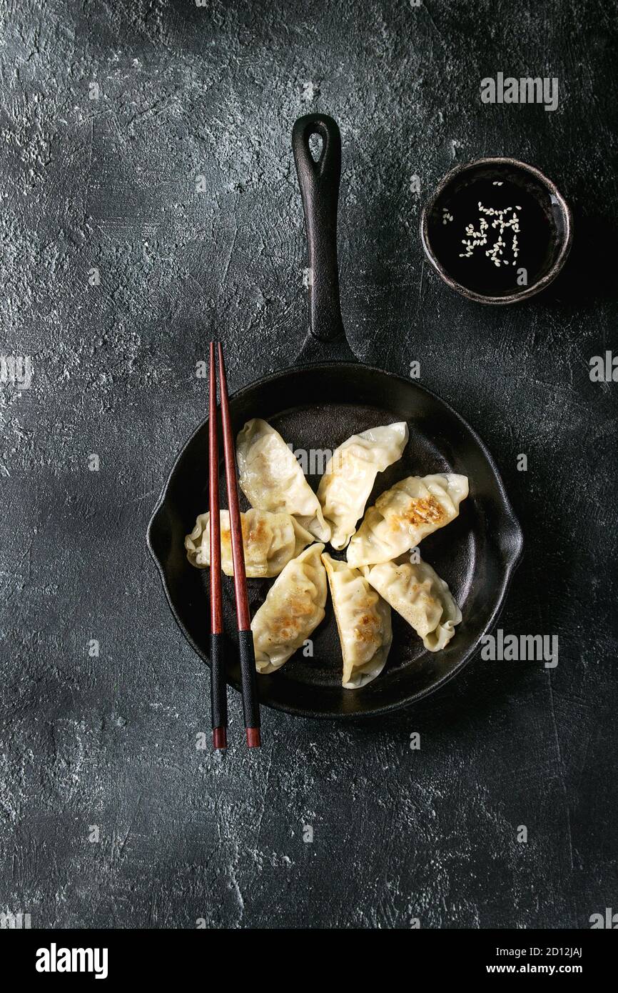 Asian dumplings Gyozas potstickers fried on cast-iron pan, served with ...