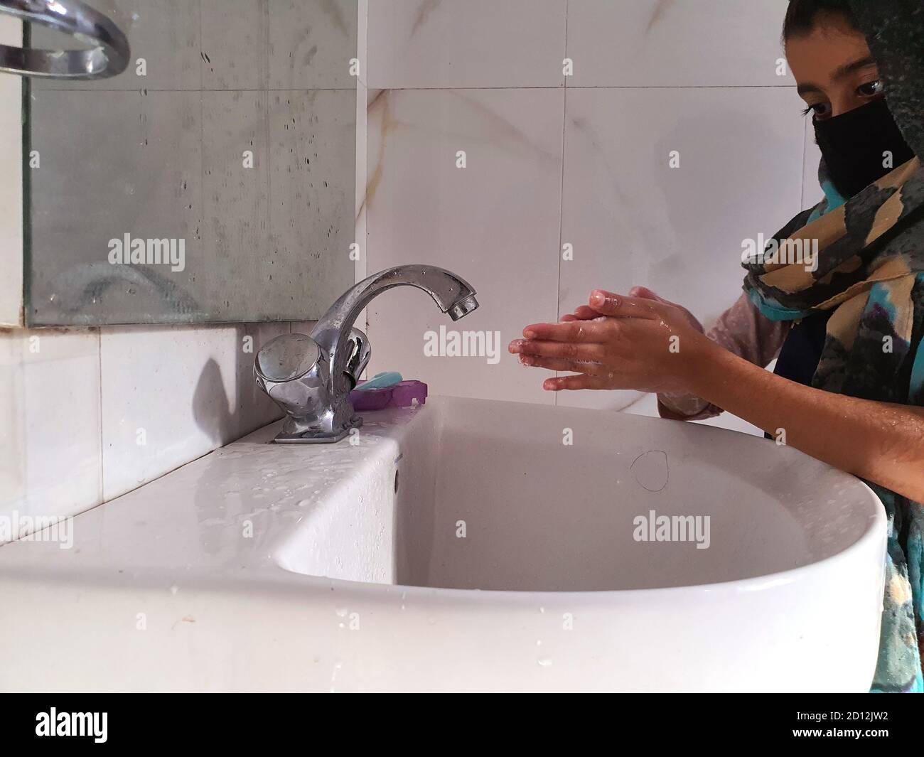 Washing hands in bathroom by masked Children during coronavirus ...