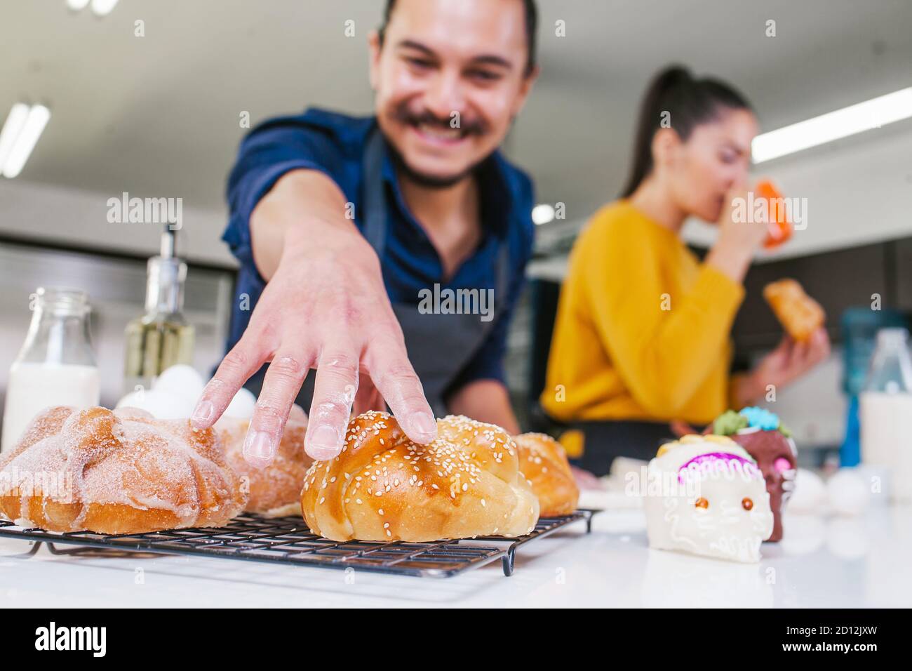 Mexican man baking bread called pan de muerto traditional from Mexico ...